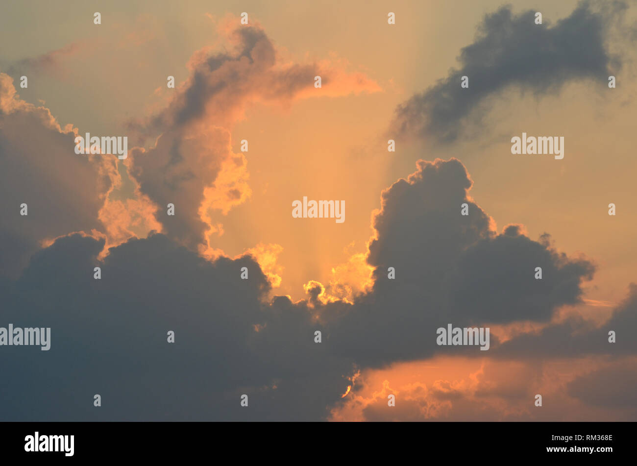 The rising sun is hidden by morning clouds. The clouds range from dark ...