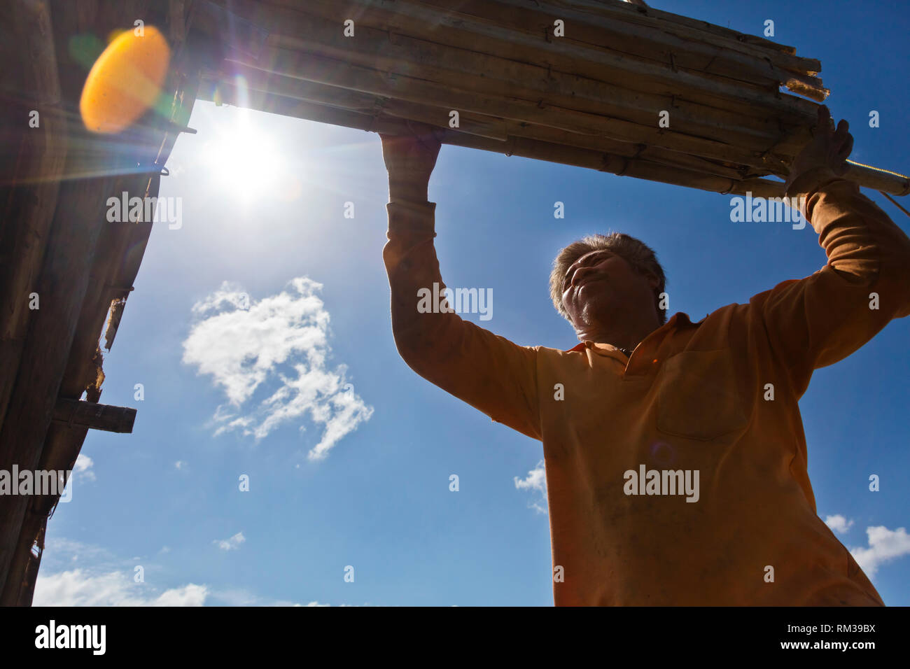 A MOKEN MAN stows his sail on his traditional boat to KHO RA ISLAND in ...