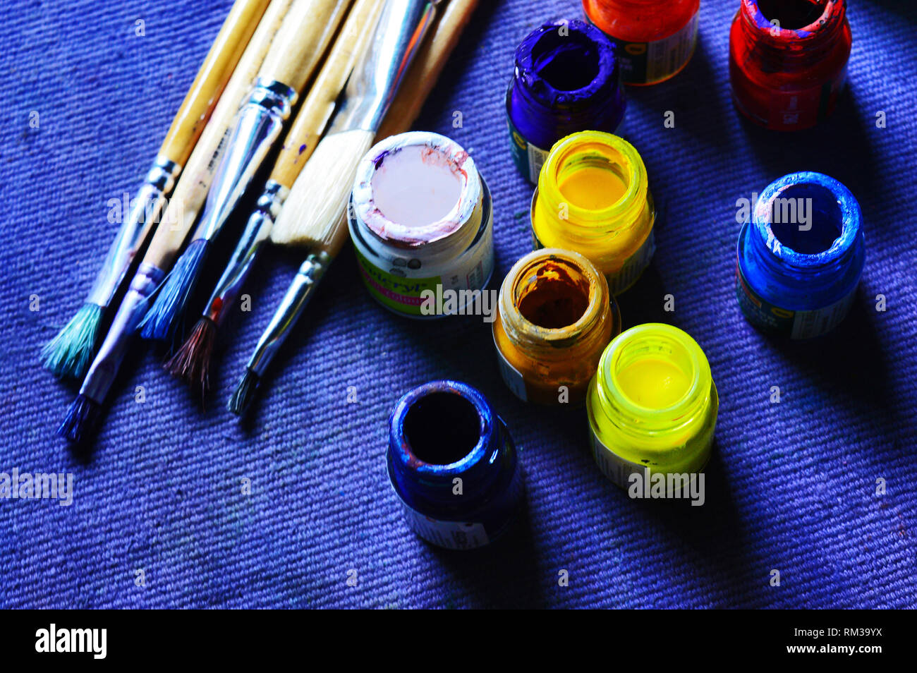 Poster colors and brushes for painting on a blue background Stock Photo ...