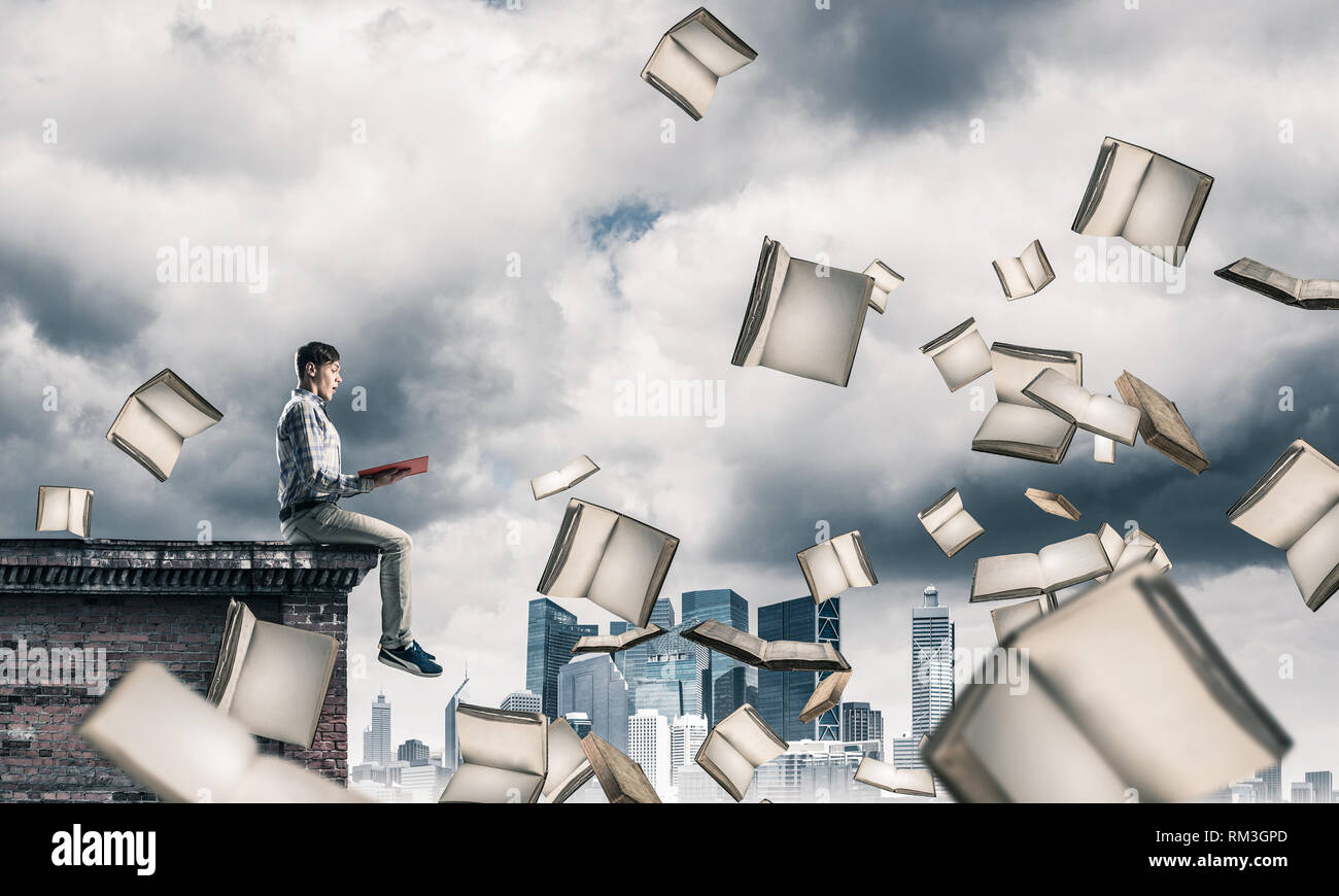 Man reading book and many of them flying in air Stock Photo - Alamy