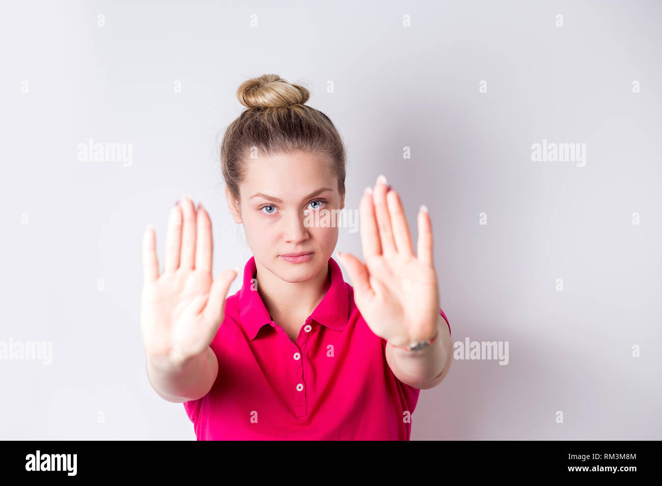Serious beautiful blonde woman with two hands shows stop gesture on ...