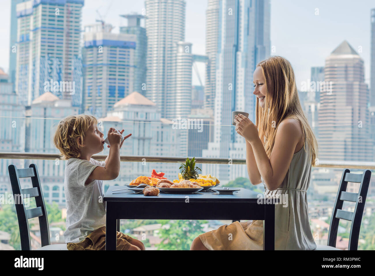 Happy family having breakfast on the balcony. Breakfast table with ...
