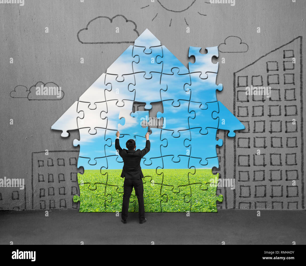 Assembling house shape puzzles on concrete wall Stock Photo - Alamy