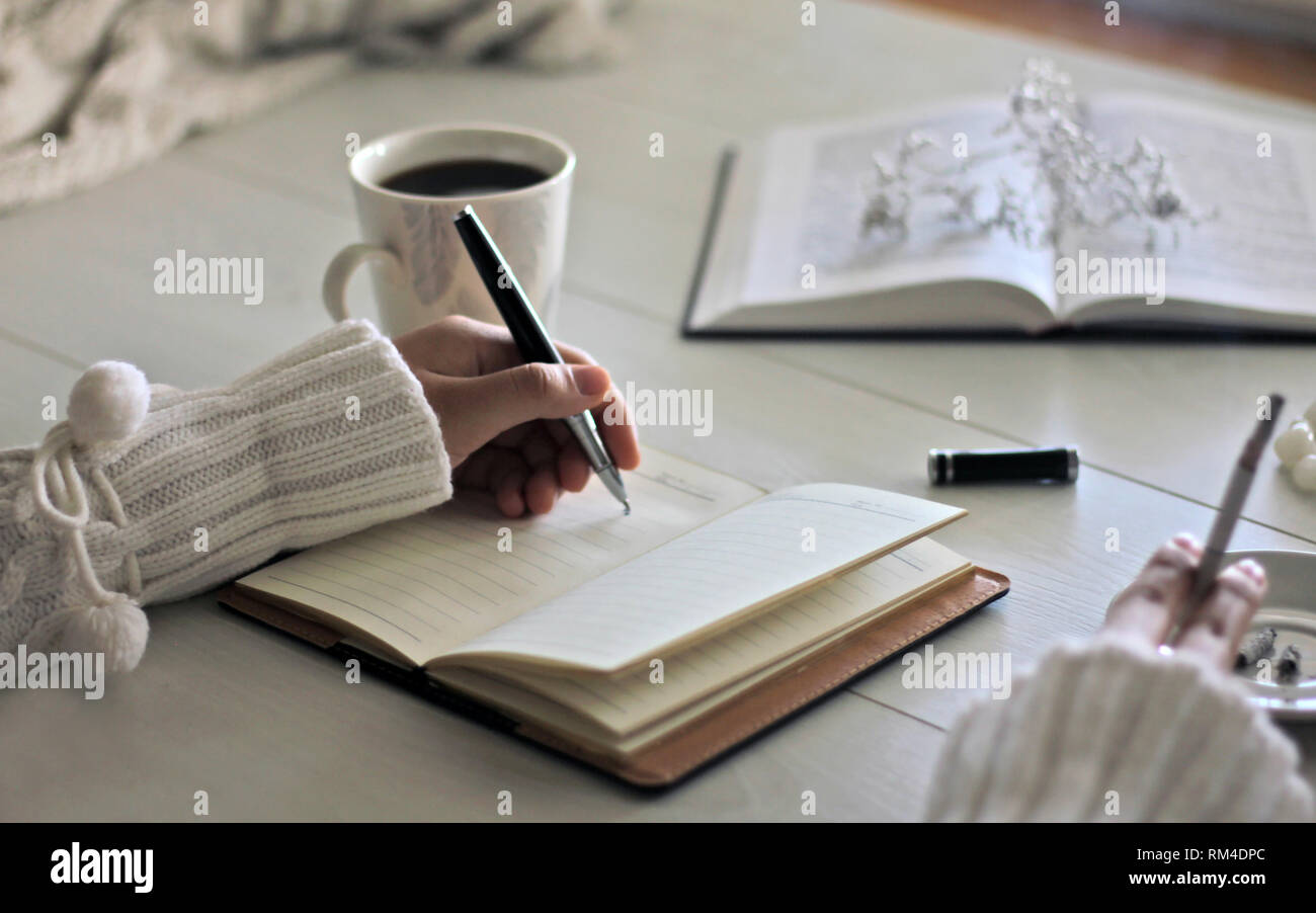 Morning mood female hands a cup of coffee, a notebook and a smoking ...
