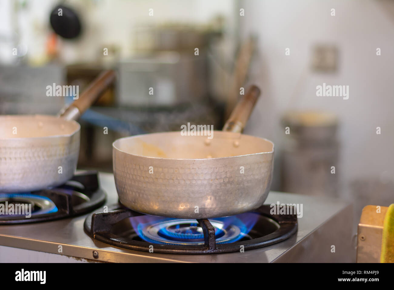 Cook with a large iron pan, boiling Stock Photo - Alamy