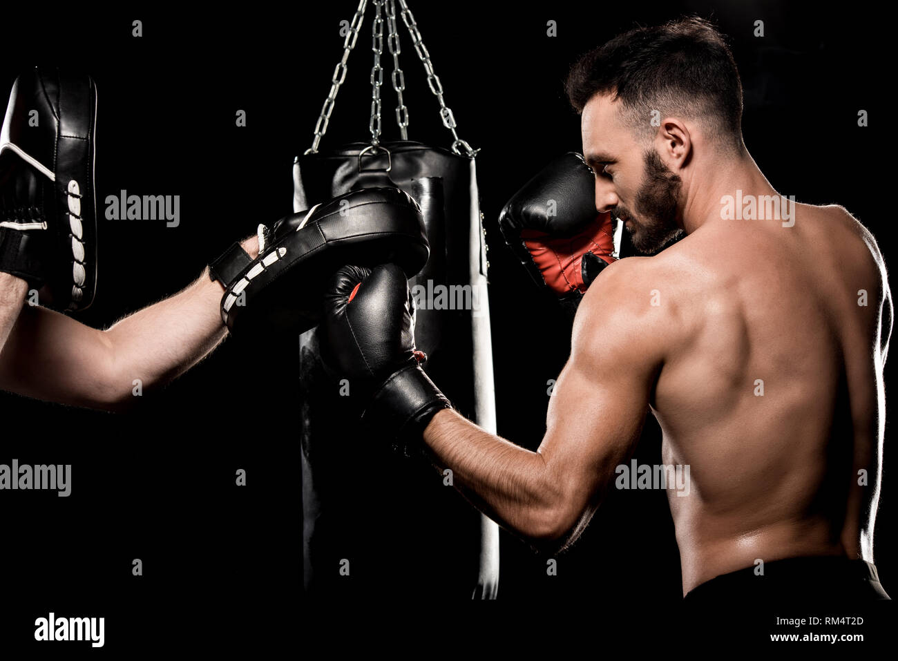 handsome boxer fighting with man in punching gloves isolated on black ...