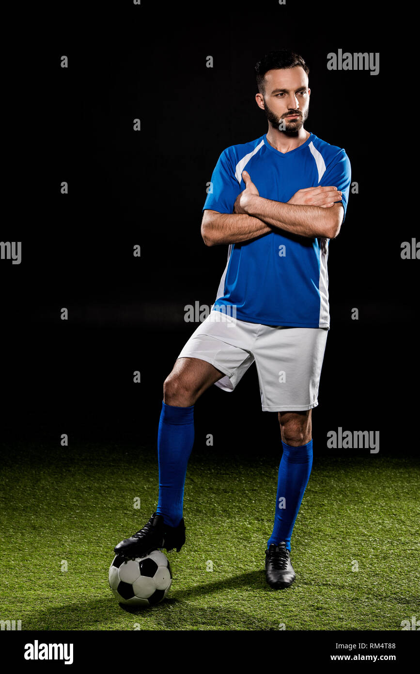 bearded football player standing with ball with crossed arms isolated ...