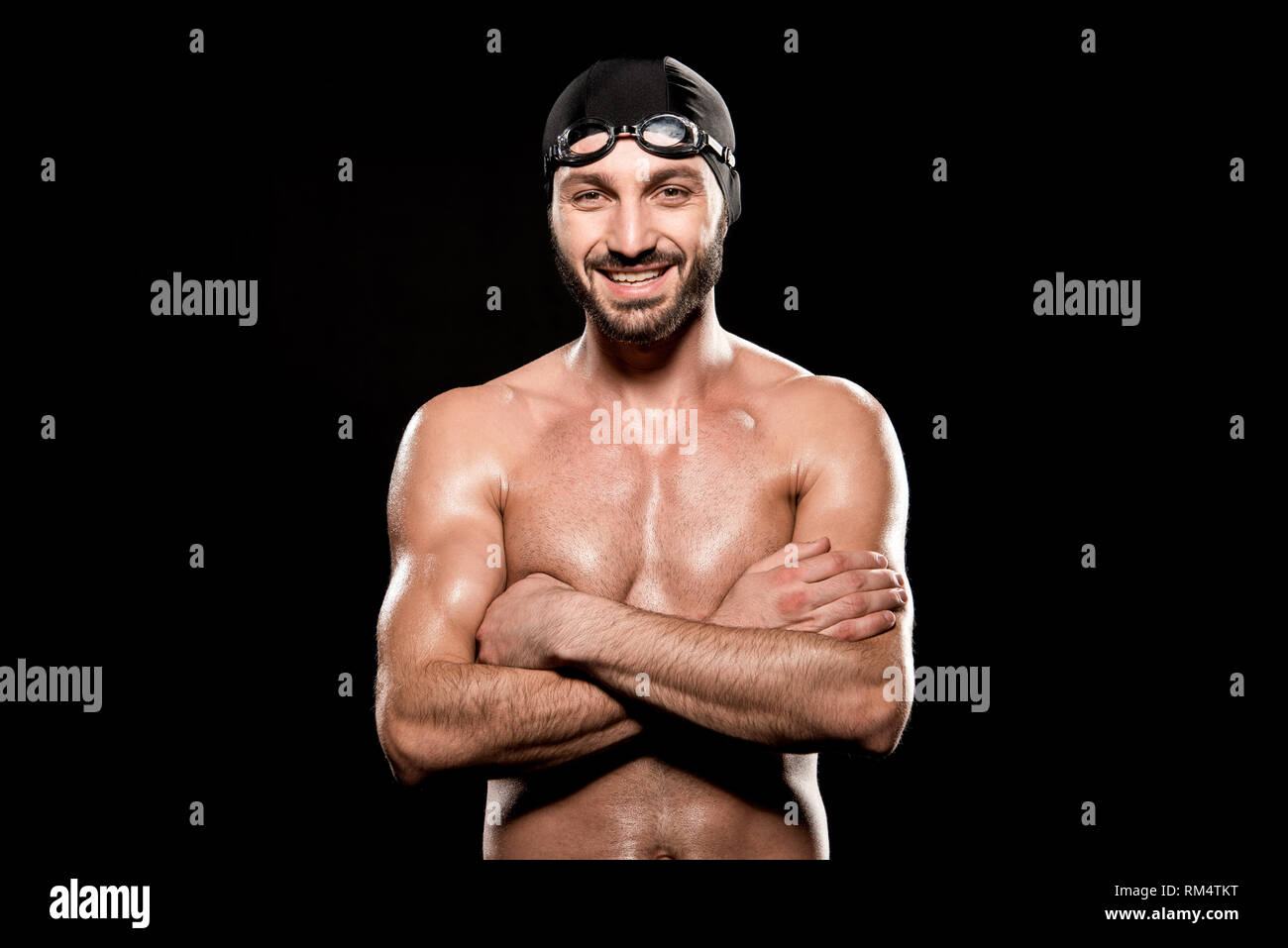 happy swimmer standing with crossed arms isolated on black Stock Photo ...