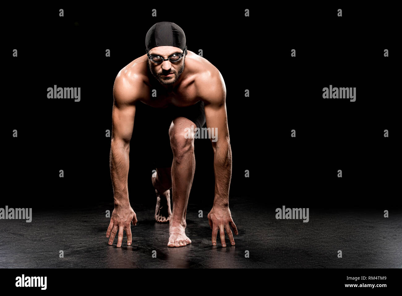 handsome swimmer standing in start position on black background Stock ...