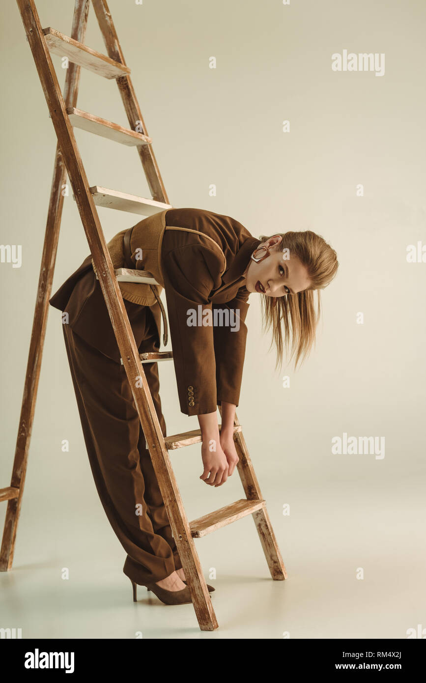 attractive young woman in vintage style posing near wooden ladder on ...