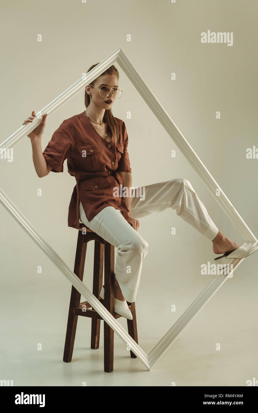 beautiful young woman posing on stool with big white frame Stock Photo ...