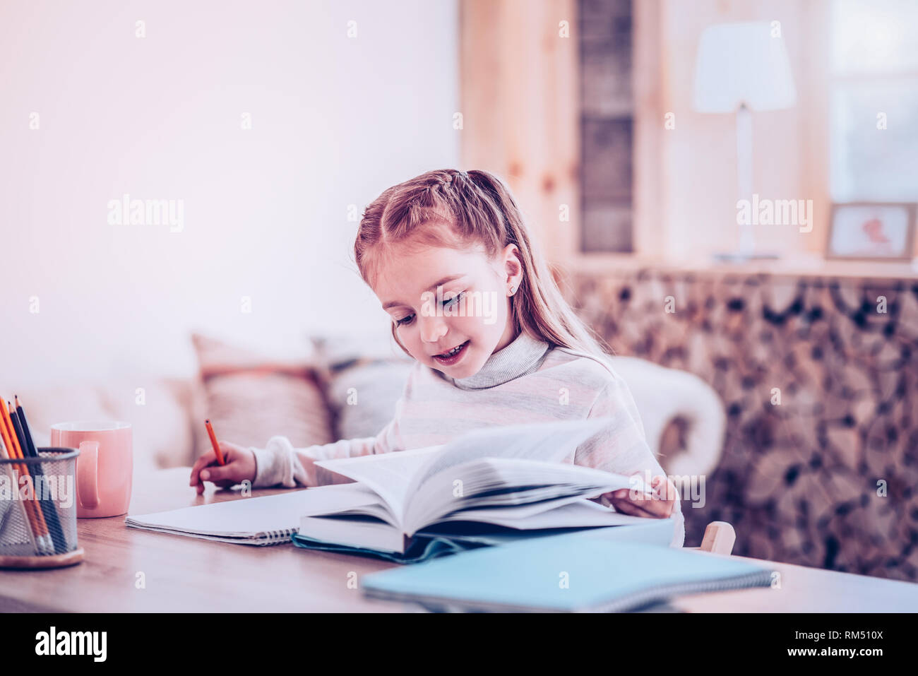 Elegant child finding information in book for homework Stock Photo - Alamy