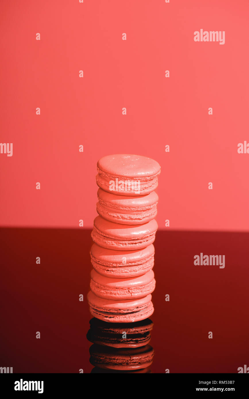 stack of sweet macarons on Living coral background. Pantone color of ...