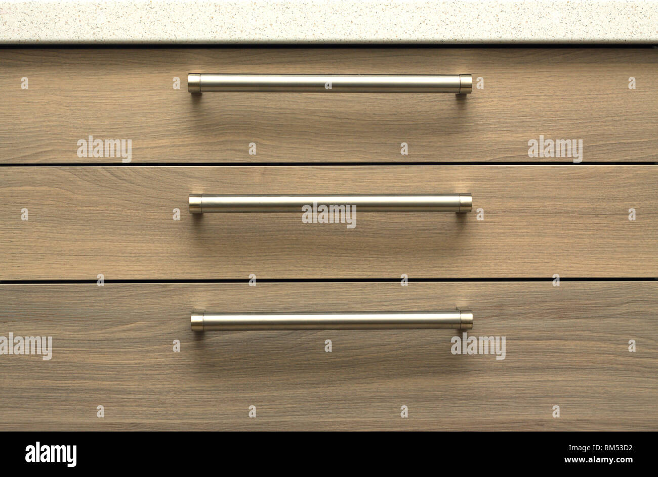 Front view of three closed sliding wooden drawers with metal long ...