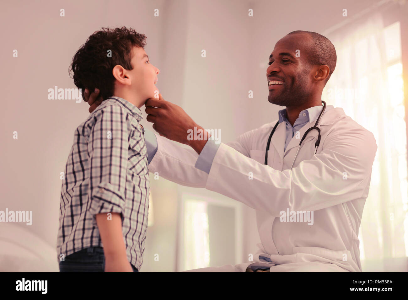 Doctor diagnosing tonsillitis by examining child throat Stock Photo - Alamy
