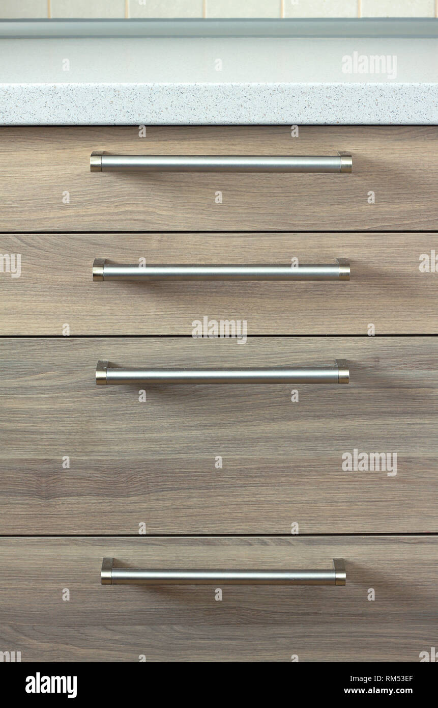 Front view of four closed sliding wooden drawers with metal long ...