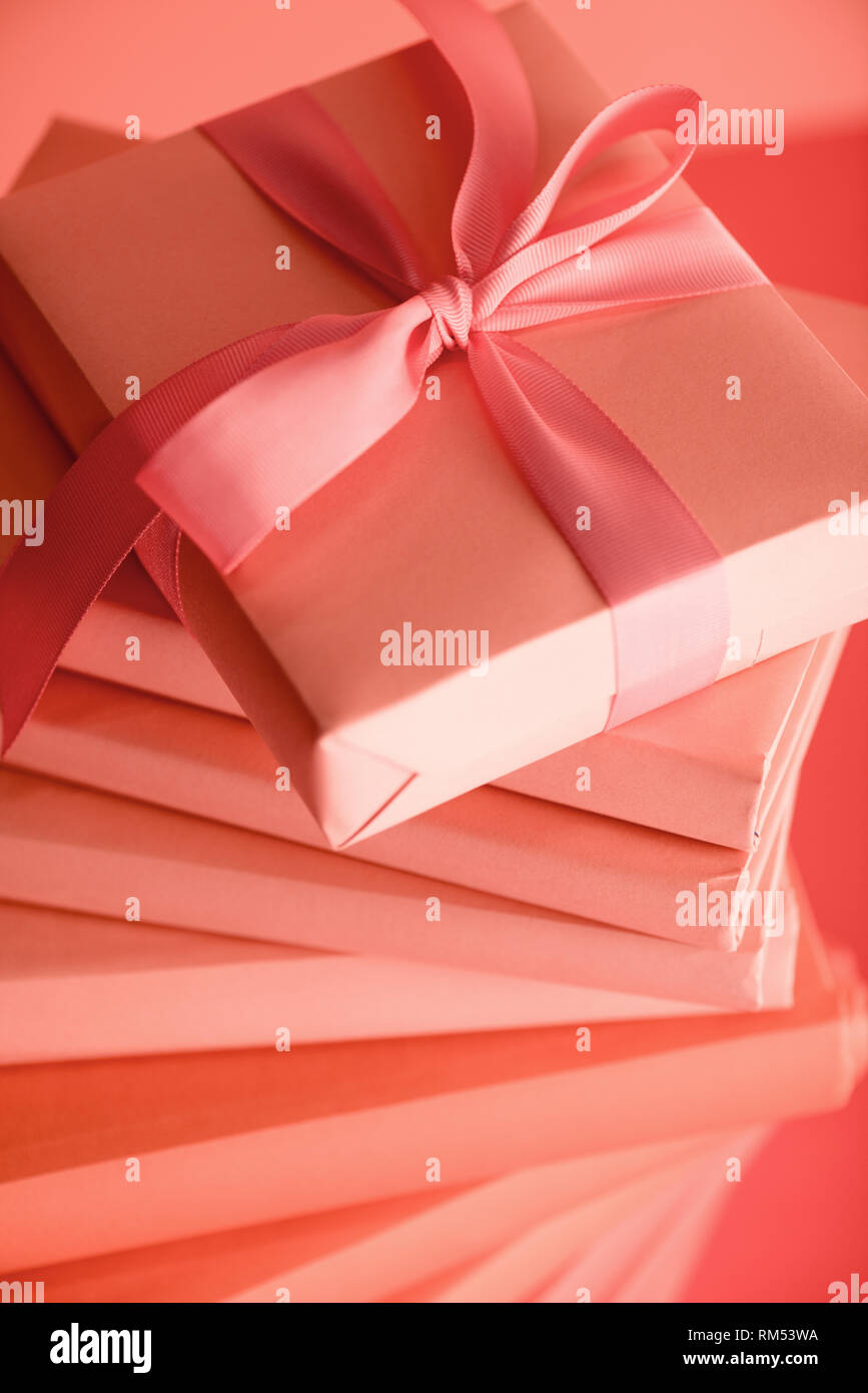 close up of stack of books and gift box in living coral color. Pantone ...