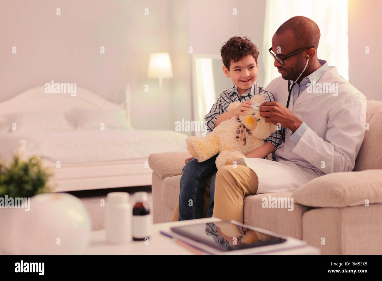 Qualified doctor playing with his young patient Stock Photo - Alamy