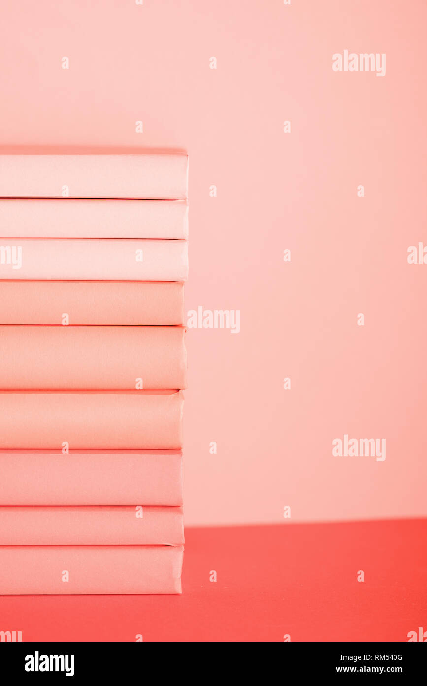pile of books on living coral background. Pantone color of the year ...