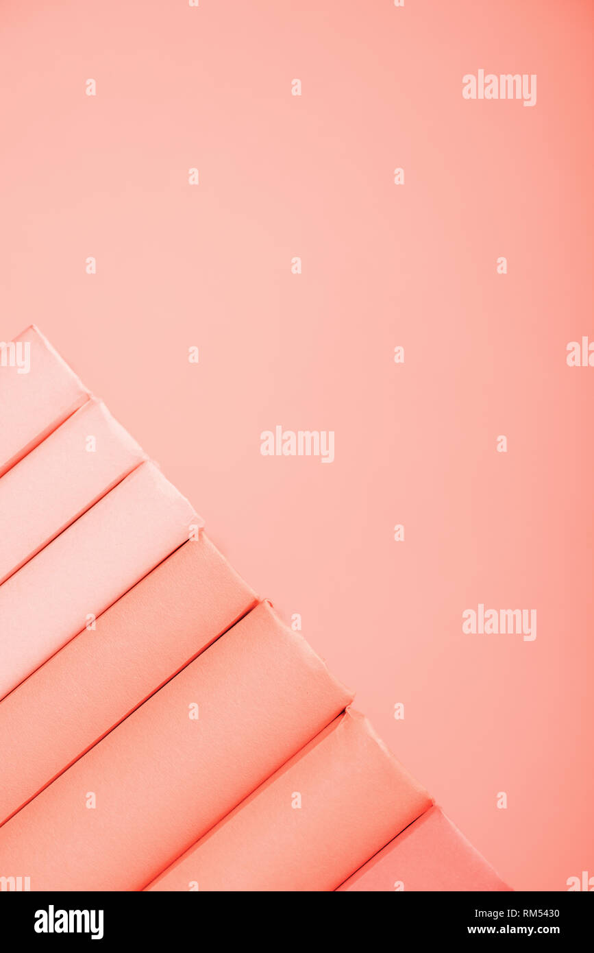 stack of books on living coral background. Pantone color of the year ...