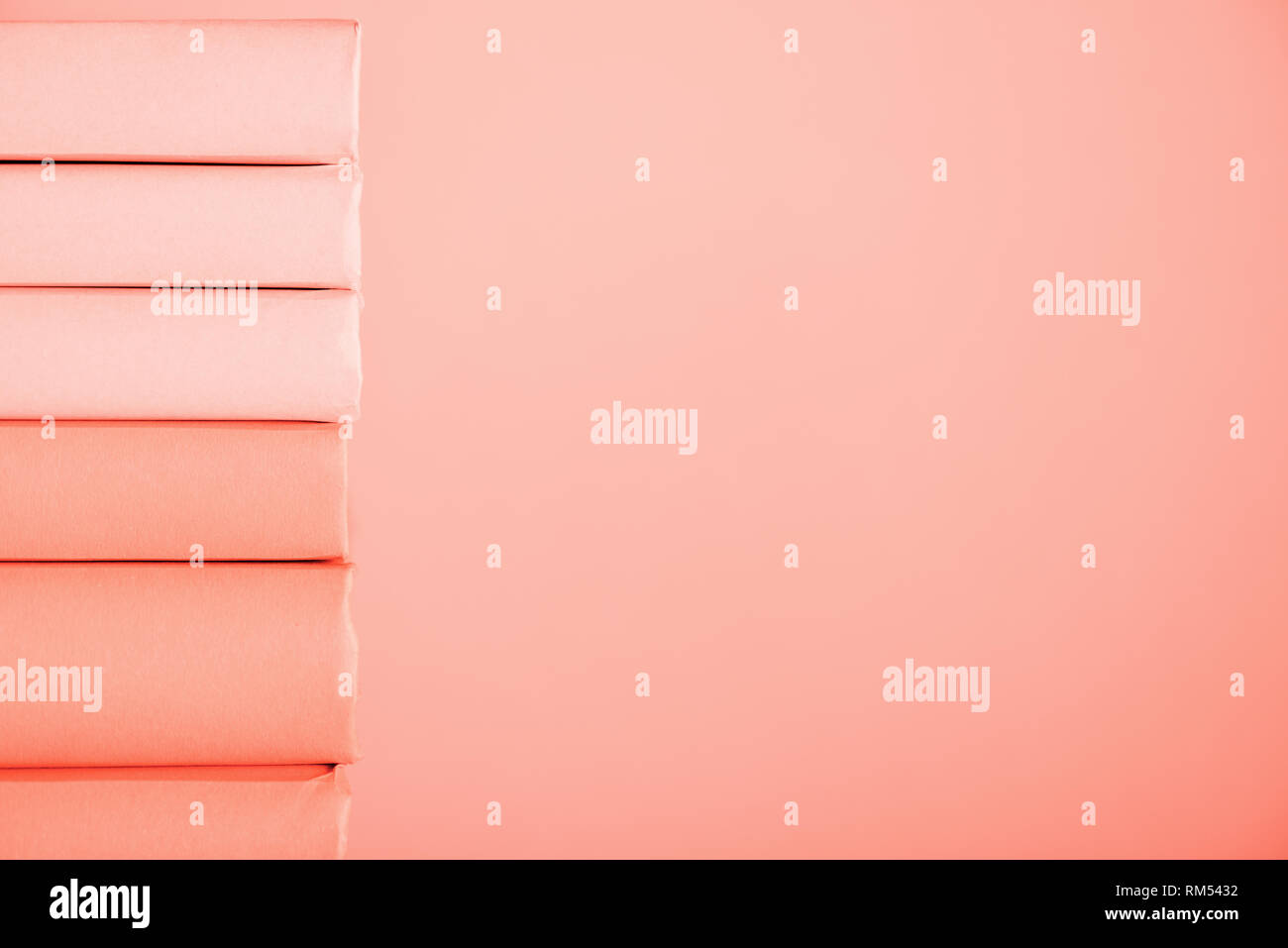 stack of books on living coral background with copy space. Pantone ...