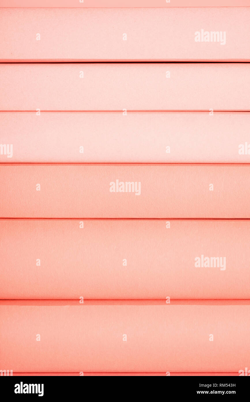 background with living coral stack of books. Pantone color of the year ...