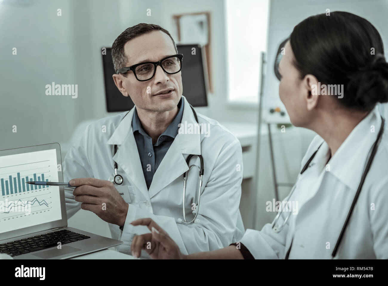 Interested researcher explaining data to his female workmate Stock ...