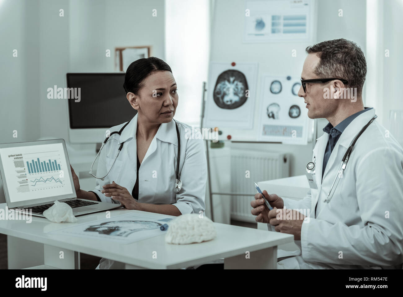 Dark-haired female doctor with stethoscope on her neck arguing Stock ...