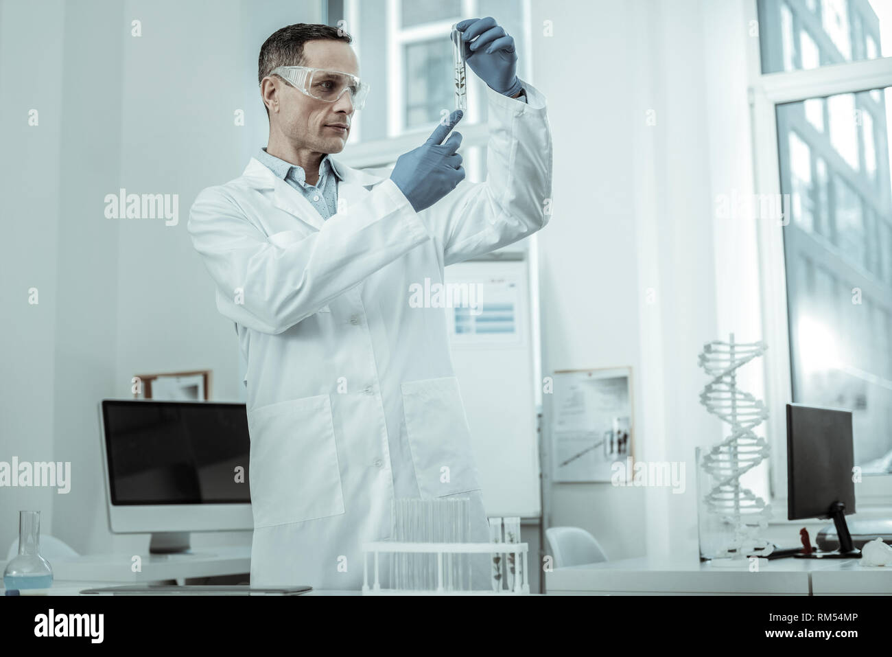 Short-haired scientist wearing special protective uniform in laboratory ...
