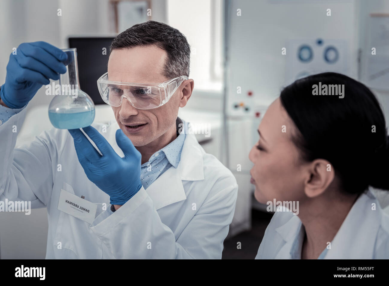 Scientist studying the content of chemical flask Stock Photo - Alamy