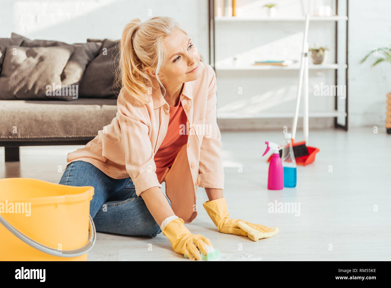 Dreamy senior woman cleaning floor with rag Stock Photo - Alamy
