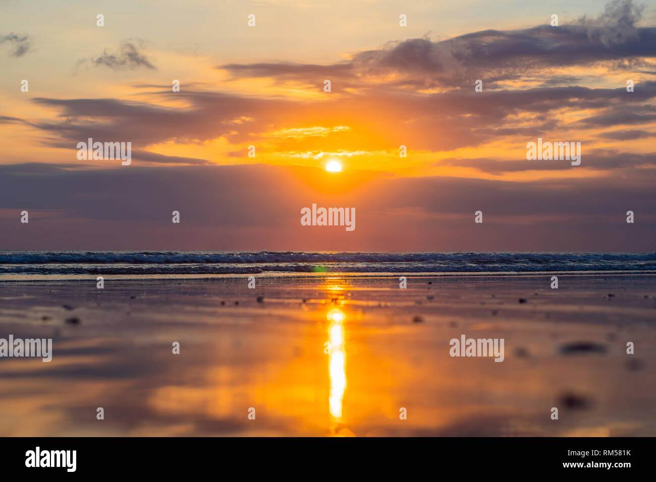 Sunset on the Kuta beach with reflection in the water on the island of ...
