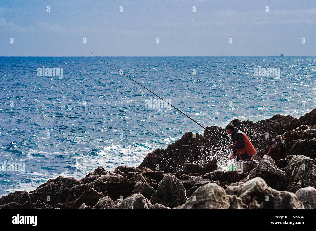 a fisherman fishing in the rocks Stock Photo - Alamy