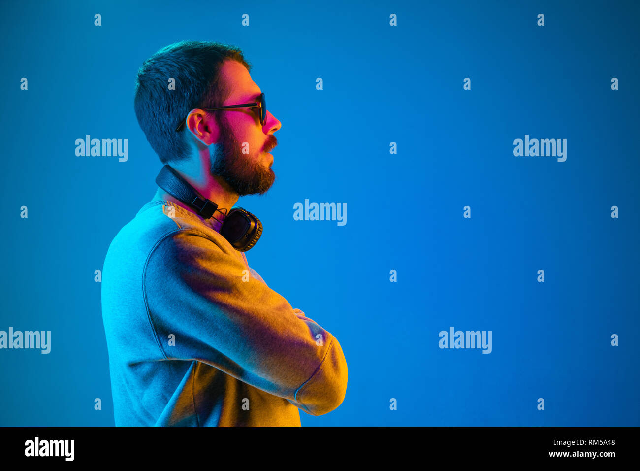 Enjoying his favorite music. Serious young stylish man in sunglasses ...