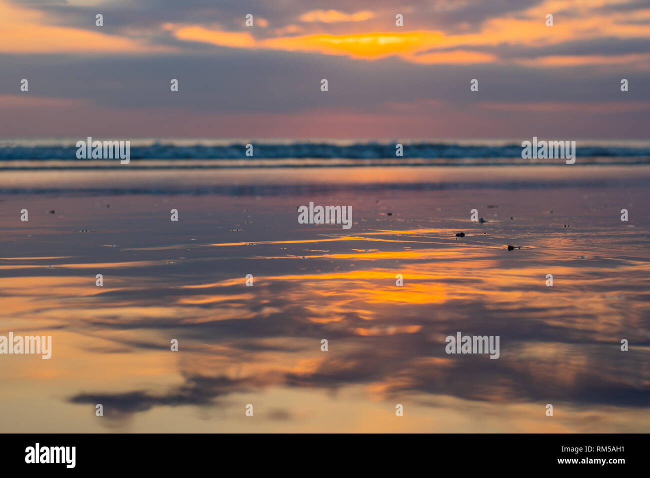 Sunset on the Kuta beach with reflection in the water on the island of ...