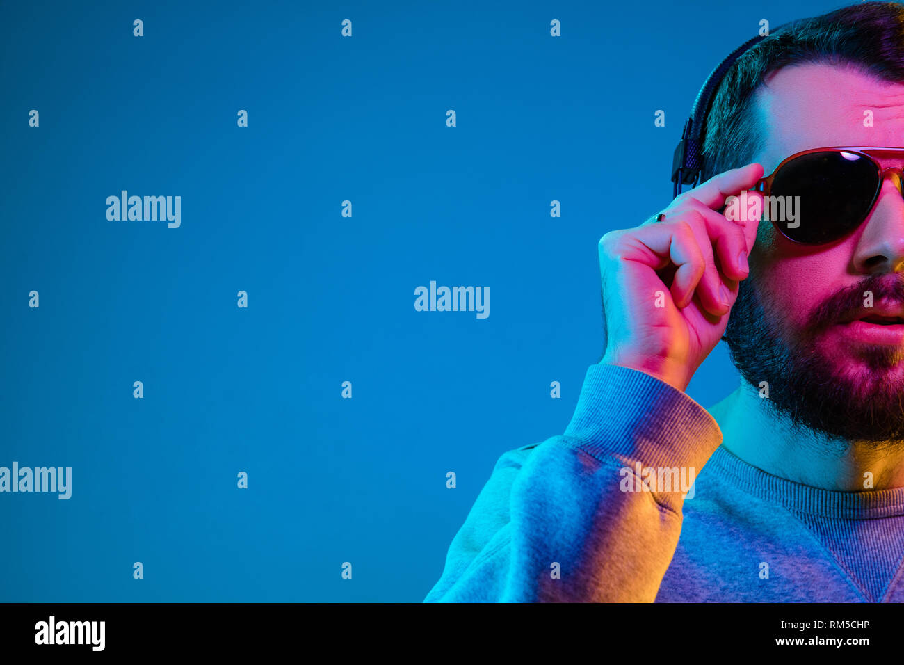 Enjoying his favorite music. Serious young stylish man in sunglasses ...