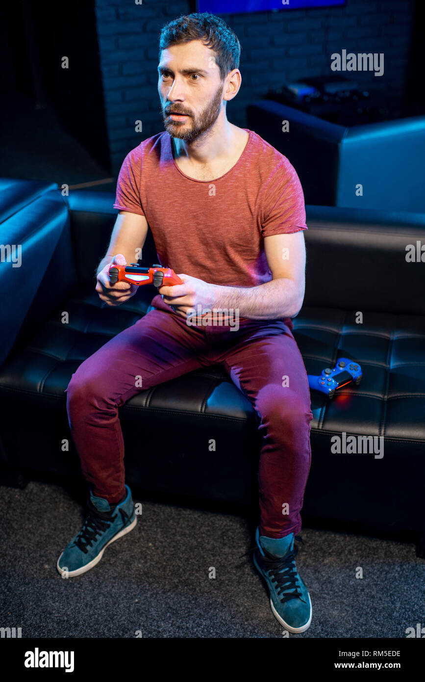 Man playing video games with gaming console and joy stick sitting on ...