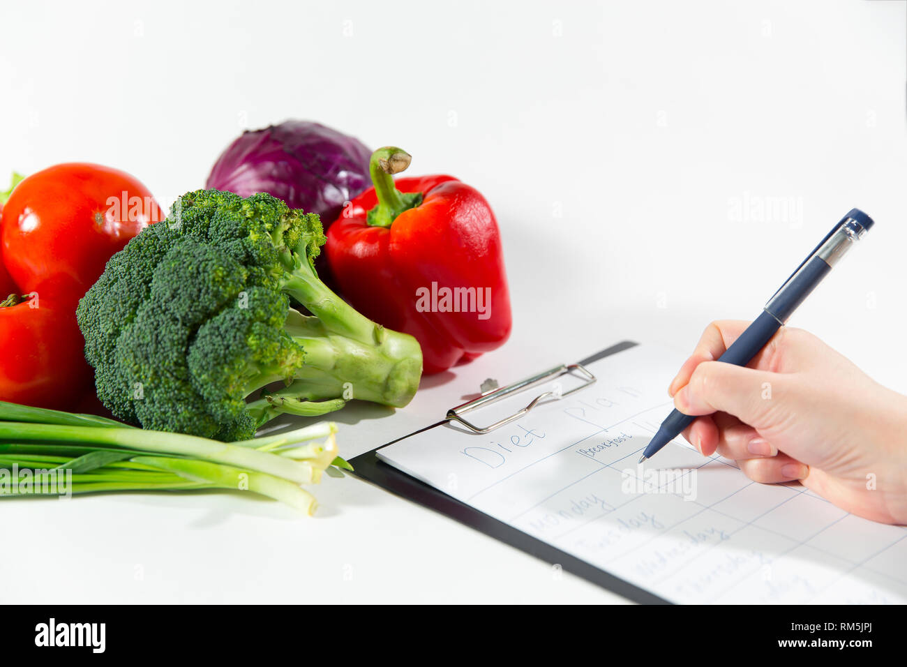 Female nutritionist doctor hand writing diet plan. Organic nutrition ...