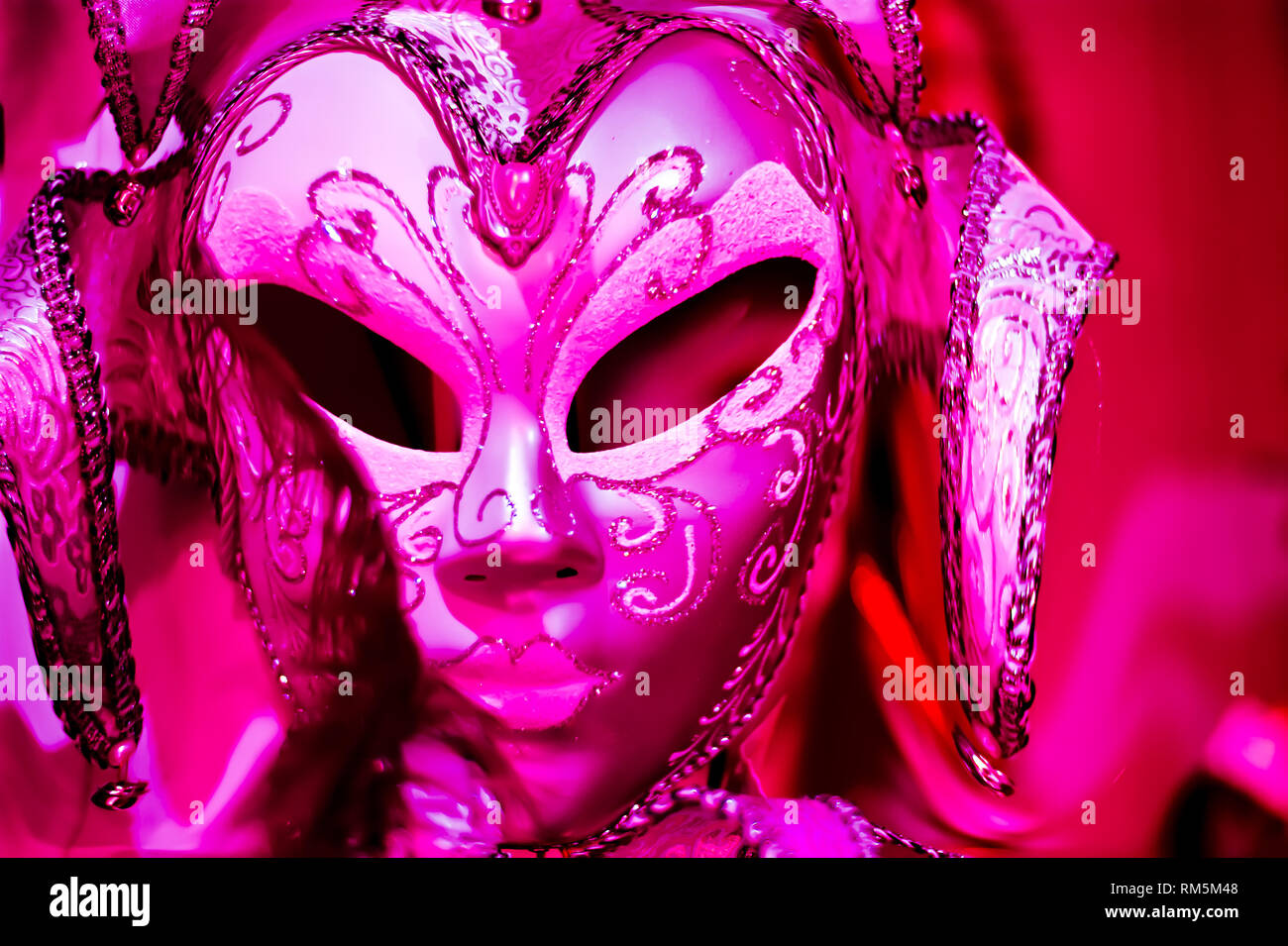 a creepy mask with a red background Stock Photo - Alamy