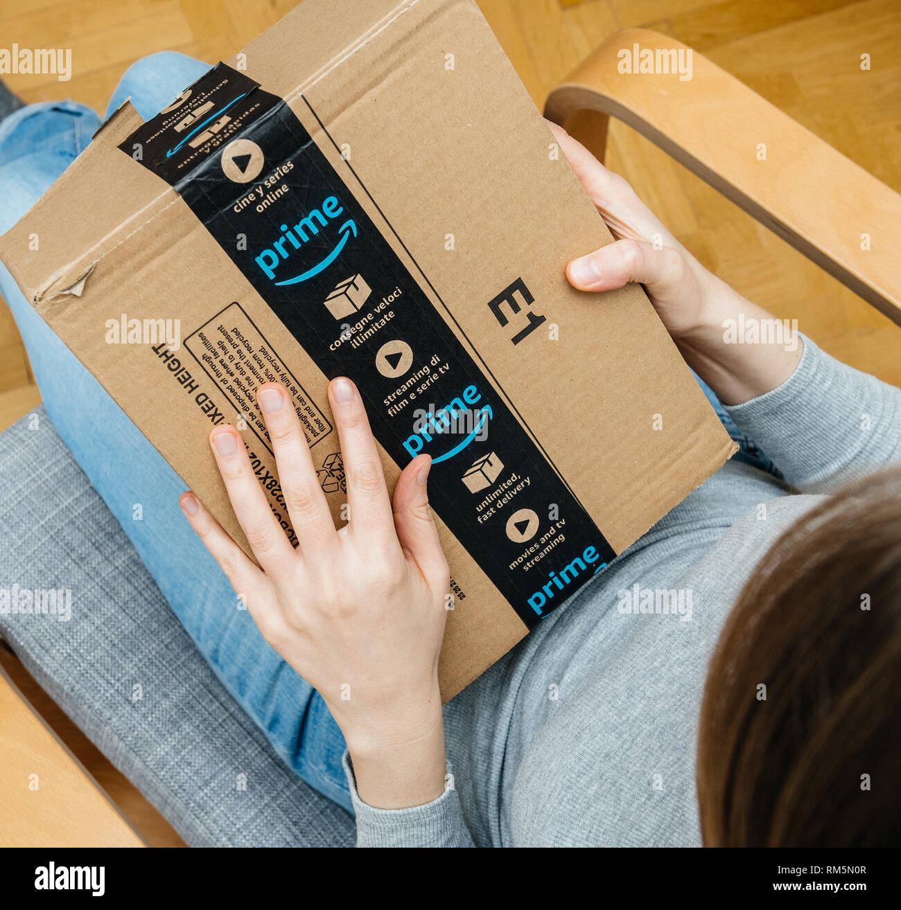 PARIS, FRANCE - NOV 4, 2017: Woman unboxing on the living room armchair ...
