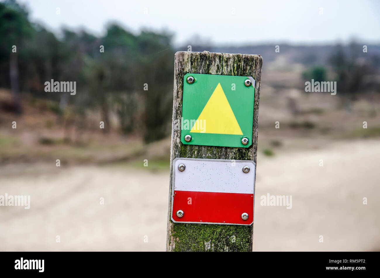 Wooden pole with green/yellow arrow sign and red/white long distance ...