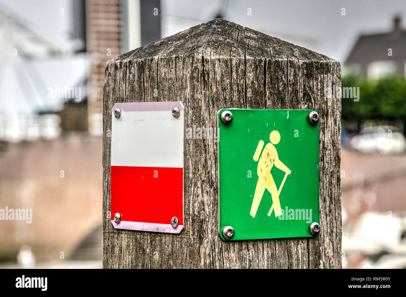 Weathered wooden pole with a red/white long distance trail marker and a ...
