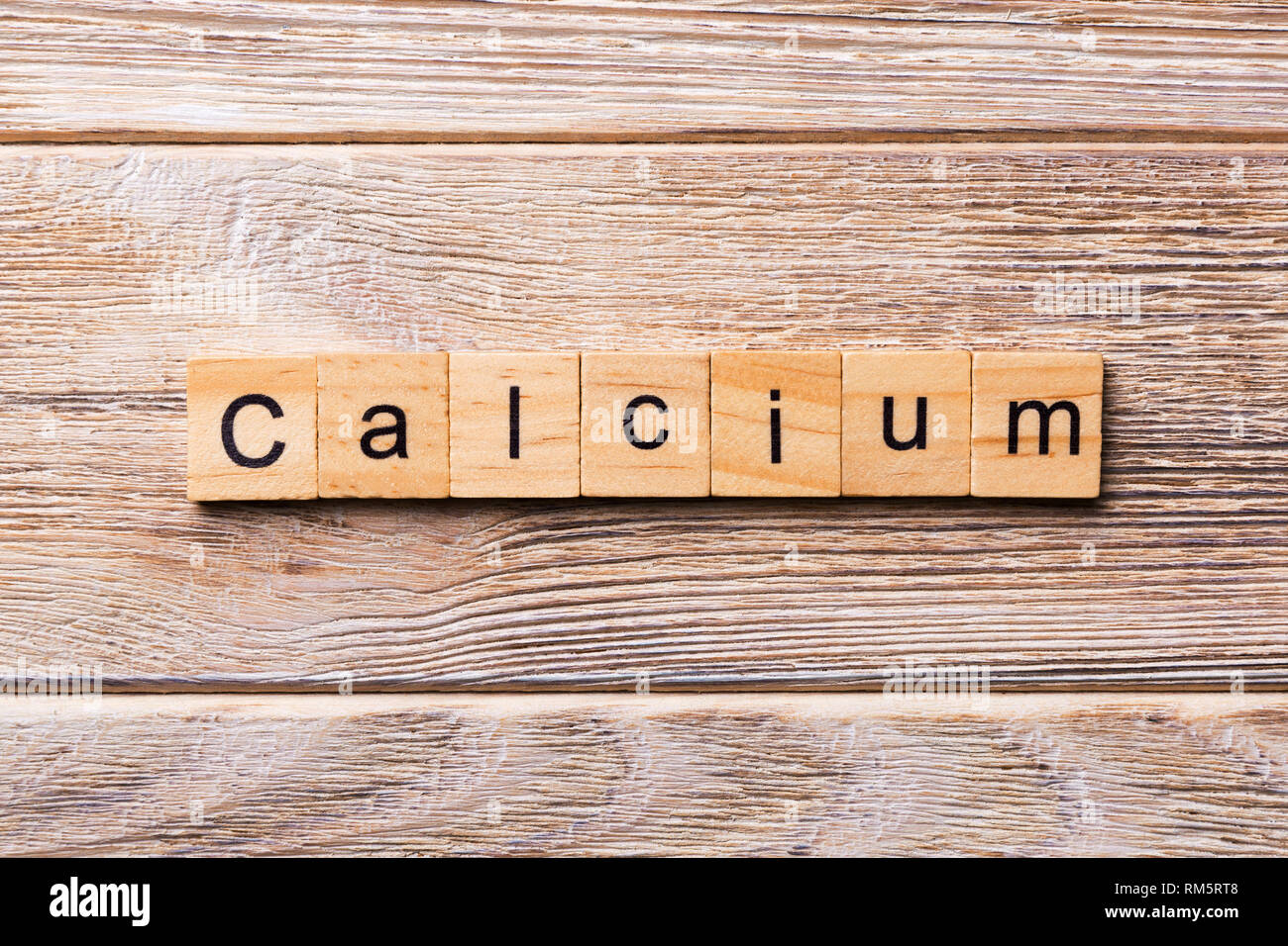 CALCIUM word written on wood block. CALCIUM text on wooden table for ...