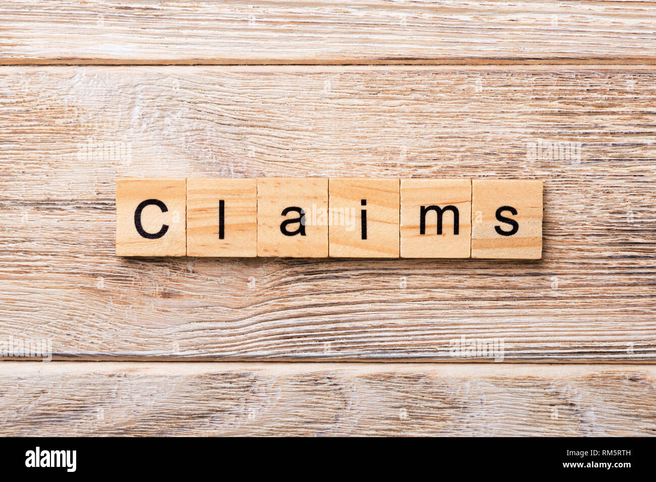 claims word written on wood block. claims text on wooden table for your ...