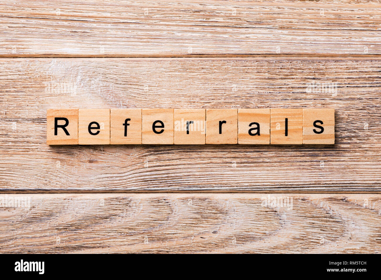 REFERRALS word written on wood block. REFERRALS text on wooden table ...