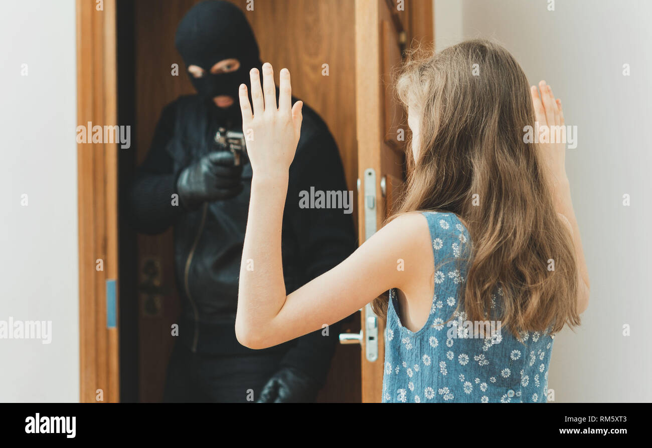 Scared little girl and angry robber with gun entering the door Stock ...