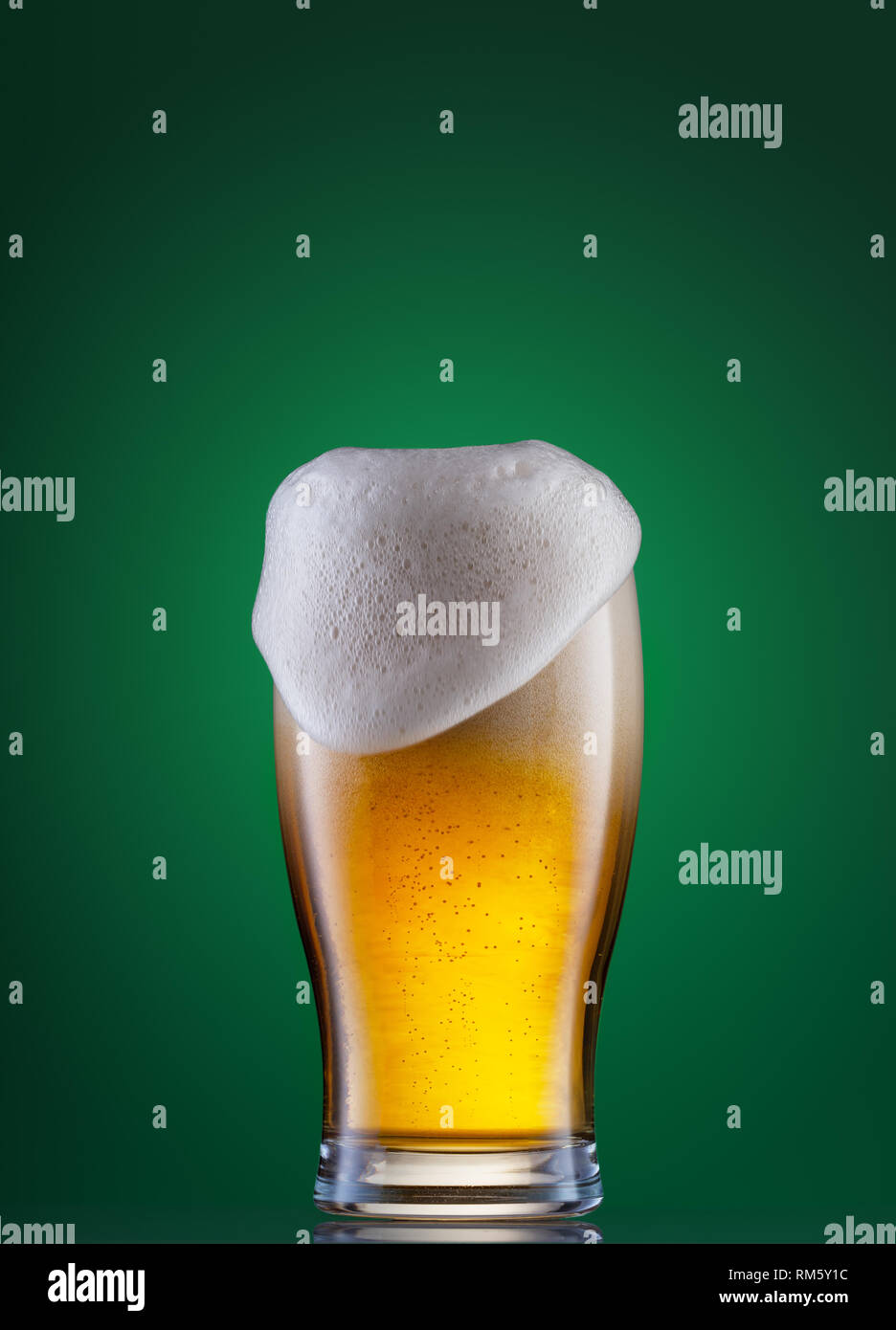 Glass of the light beer with foam on green background Stock Photo - Alamy