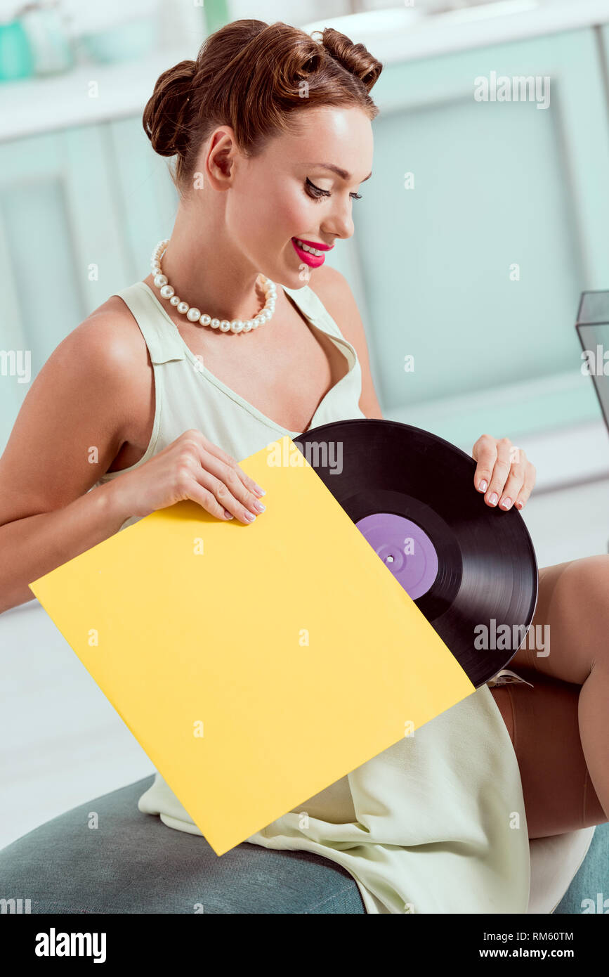 Pretty pin up girl getting vinyl record out of cover Stock Photo - Alamy
