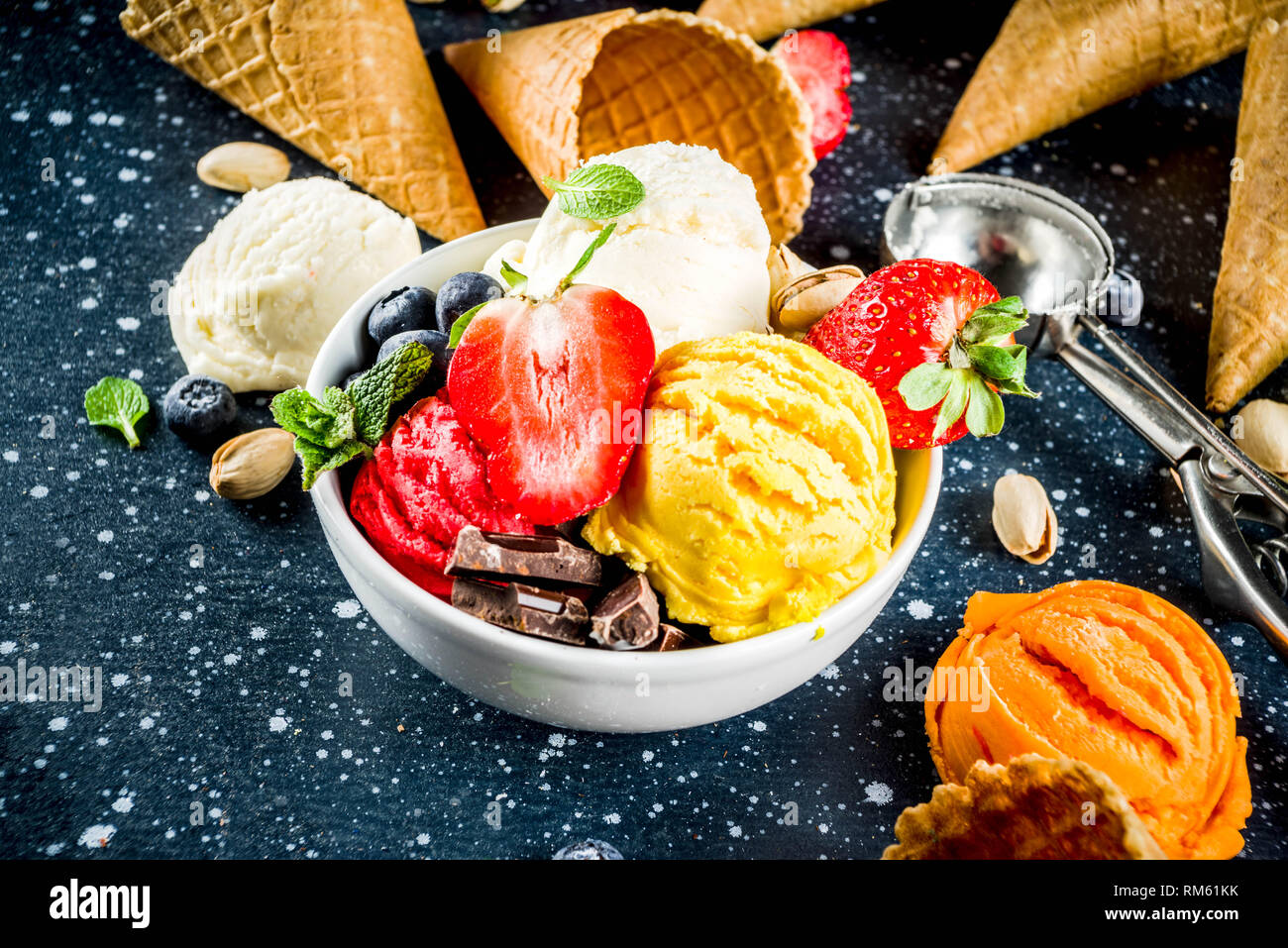 Colorful fruit and berry, nut, chocolate and vanilla ice cream, with ...