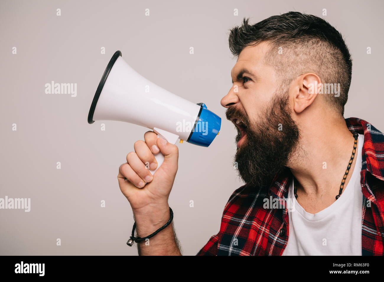 handsome angry man yelling into megaphone, isolated on grey Stock Photo ...